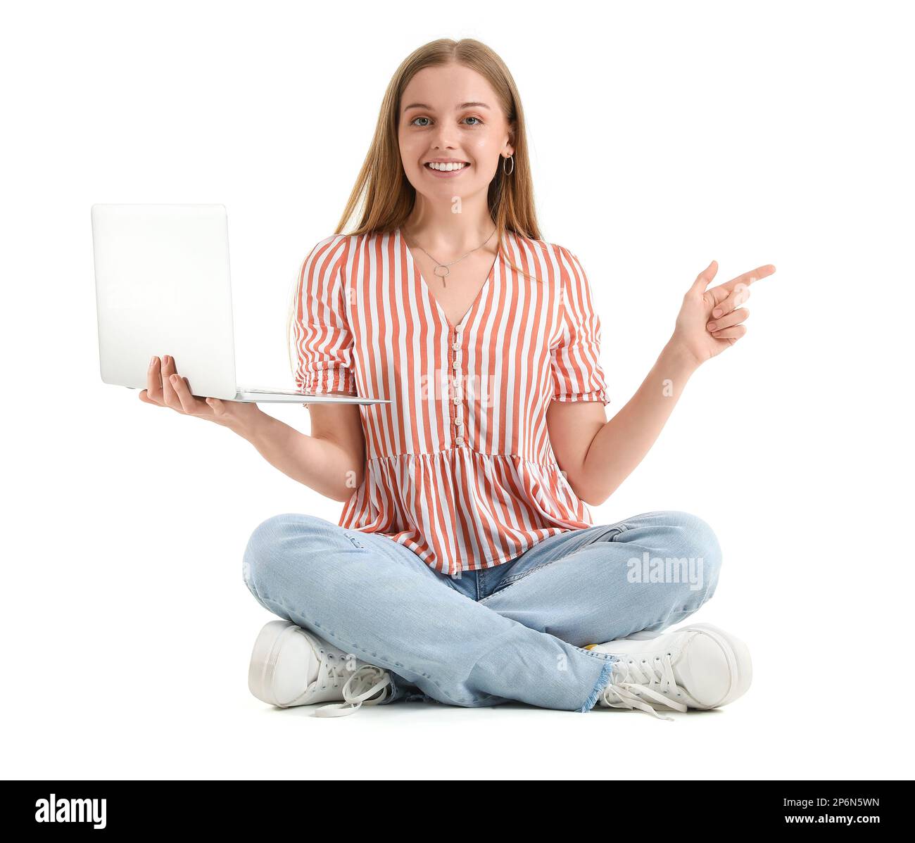 Beautiful girl with laptop pointing at something on white background ...