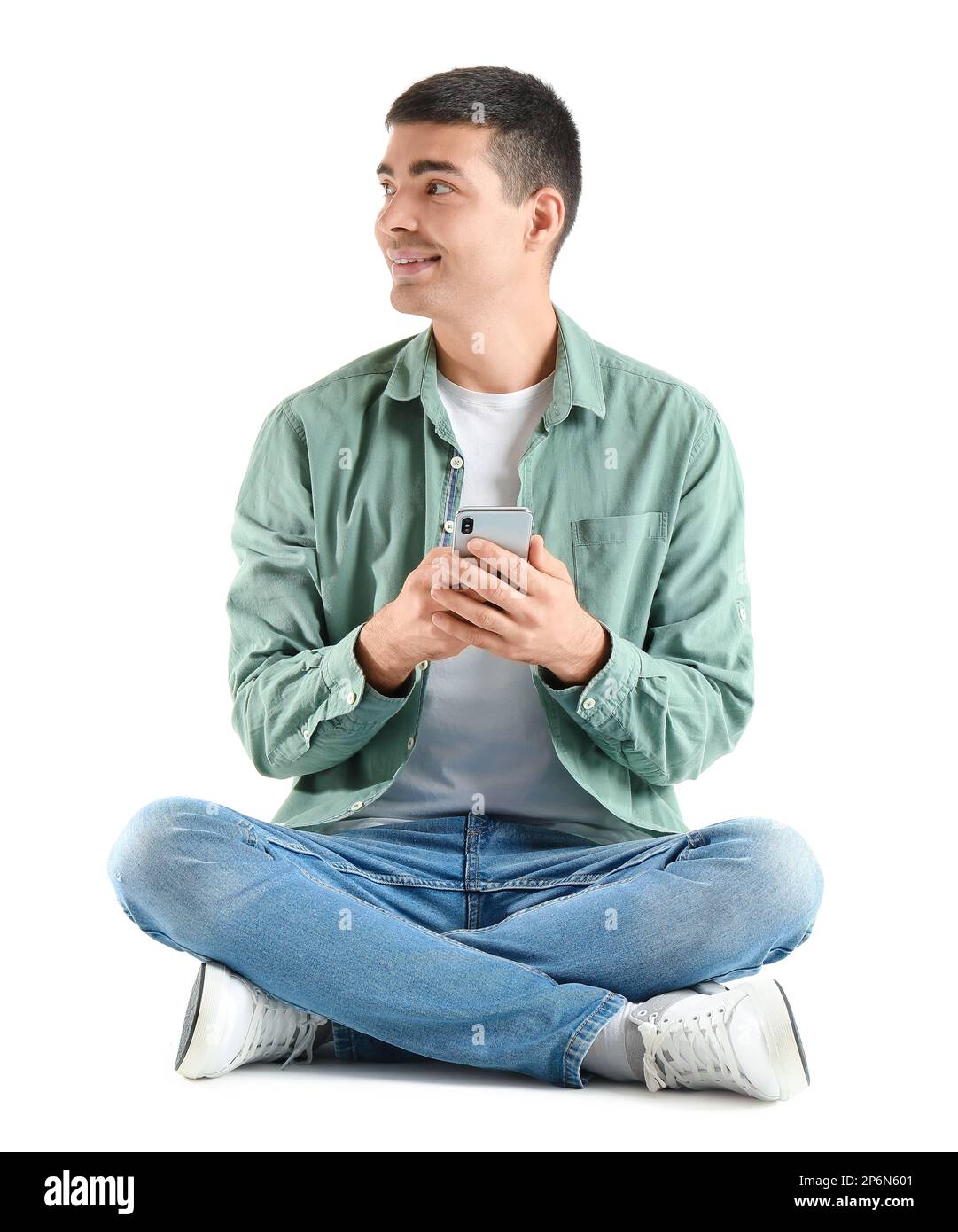 Young guy with mobile phone sitting on white background Stock Photo - Alamy