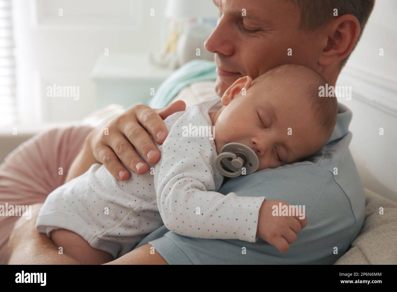 Happy father holding his cute sleeping baby with pacifier at home Stock ...