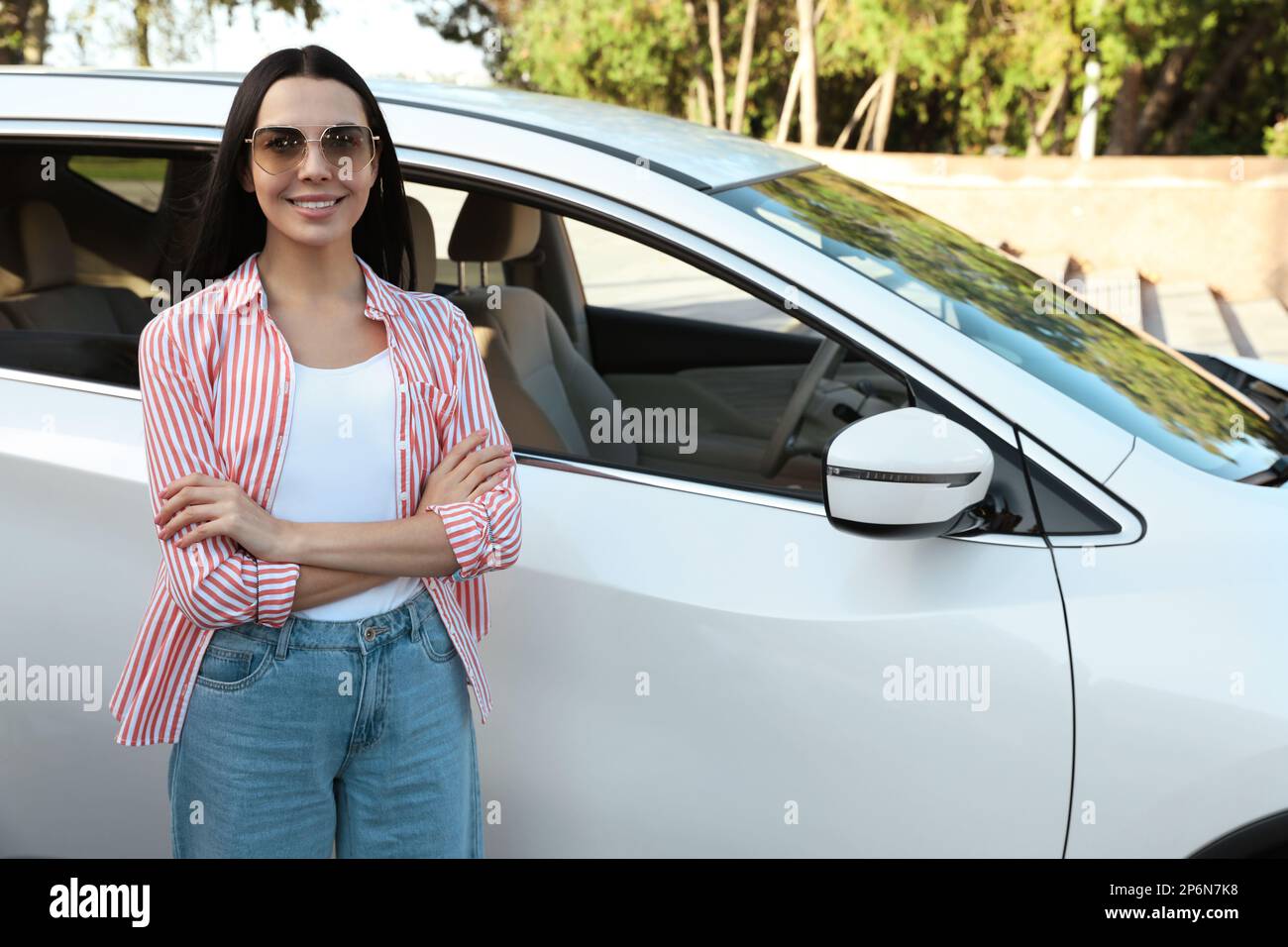 Beautiful young driver near modern car on city street Stock Photo - Alamy