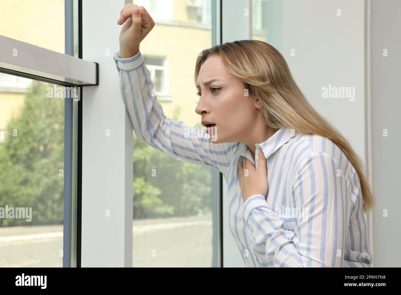 Young woman suffering from pain during breathing near window Stock ...