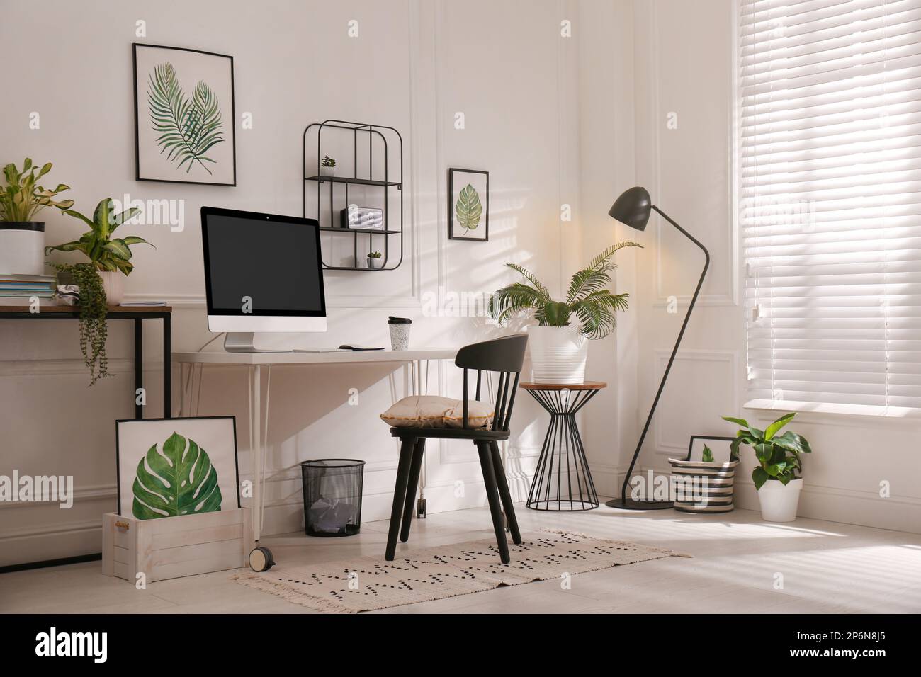 Comfortable workplace with modern computer and houseplants in room ...