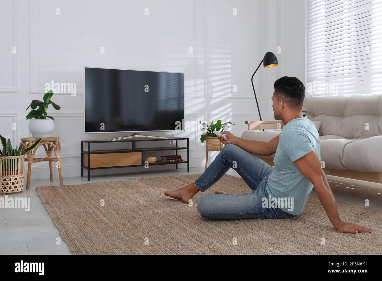 Man watching television at home. Living room interior with TV on stand ...