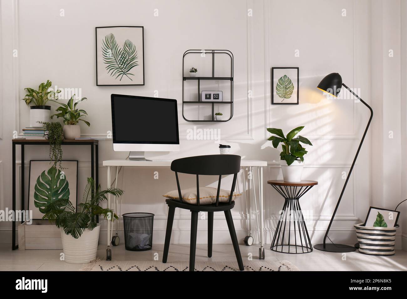 Comfortable workplace with modern computer and houseplants in room ...