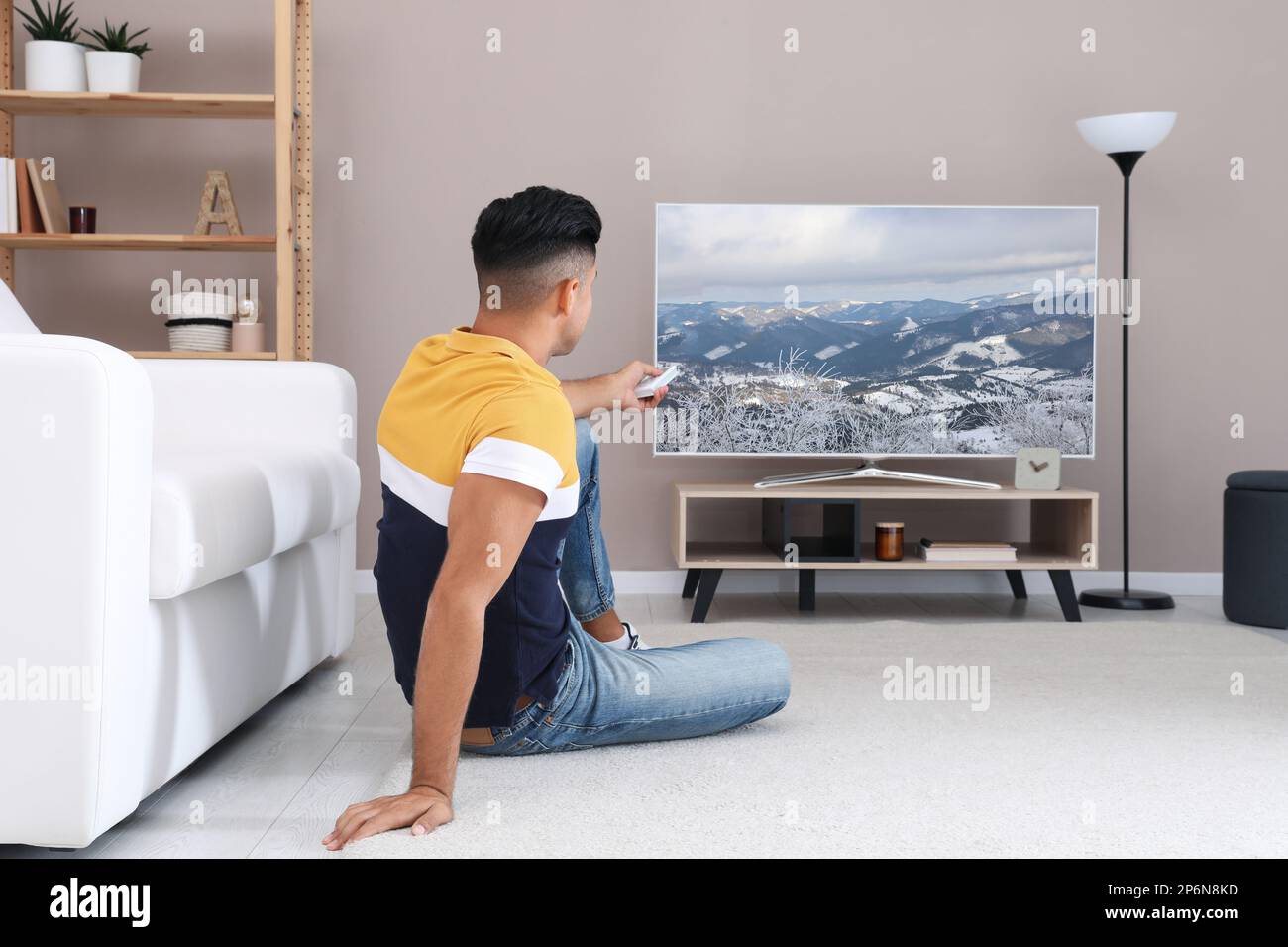 Man watching television at home. Living room interior with TV on stand ...
