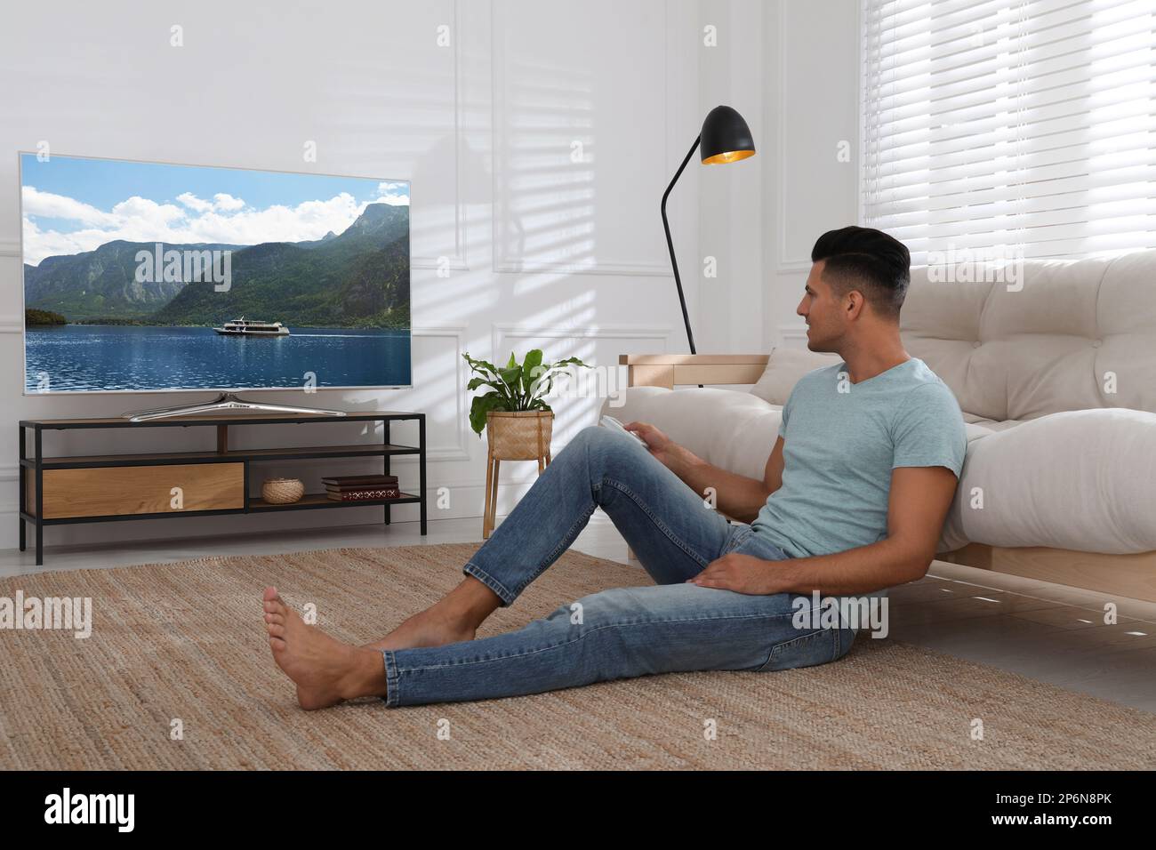 Man watching television at home. Living room interior with TV on stand ...