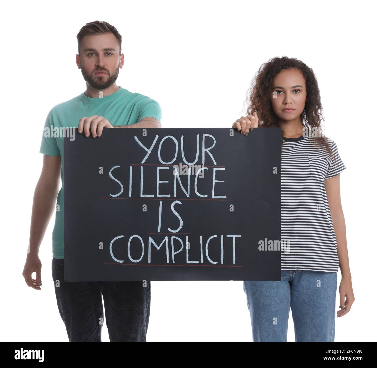 Young man and African American woman holding sign with phrase Your Silence Is Complicit on white ...