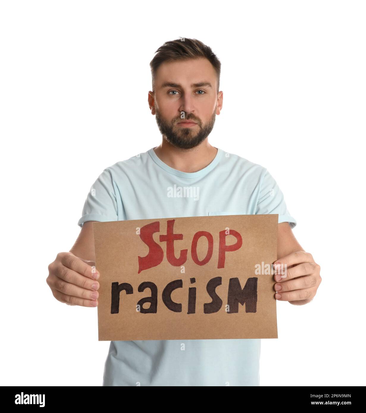 Young man holding sign with phrase Stop Racism on white background ...