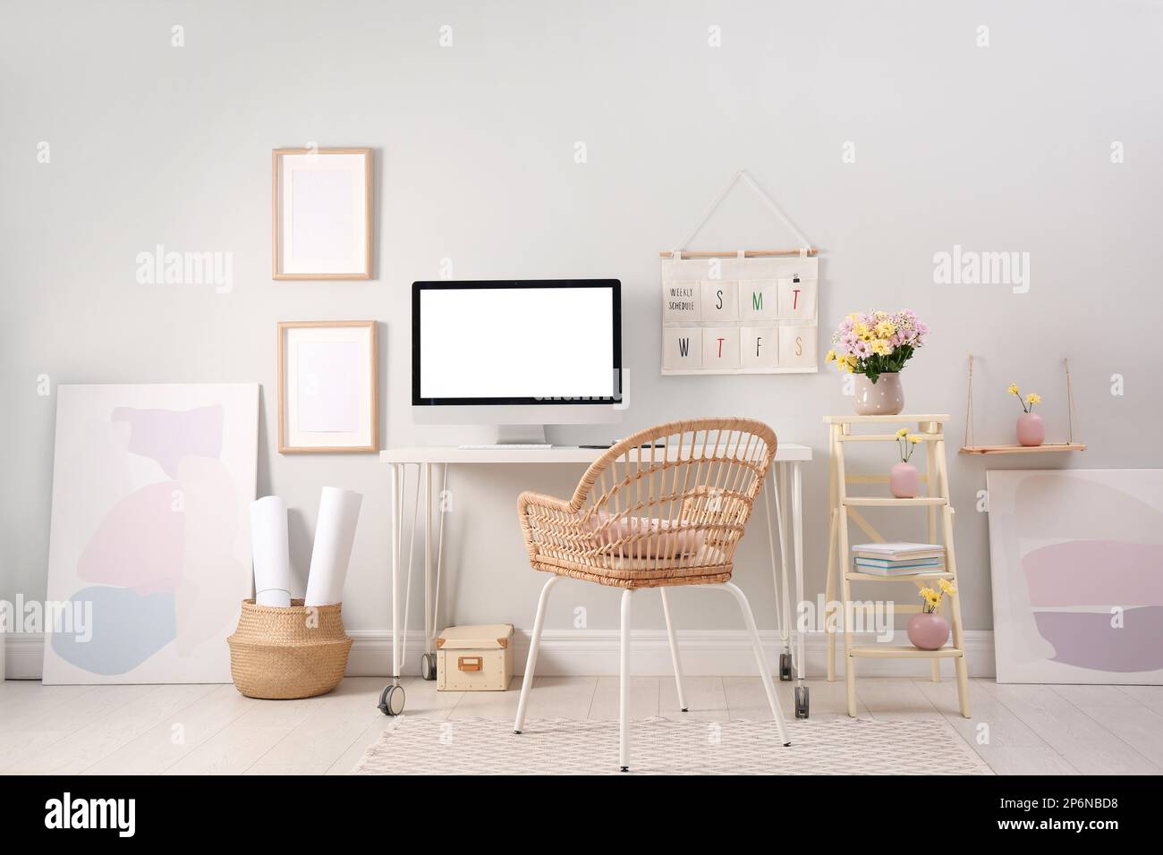 Comfortable workplace with modern computer and flowers in room ...