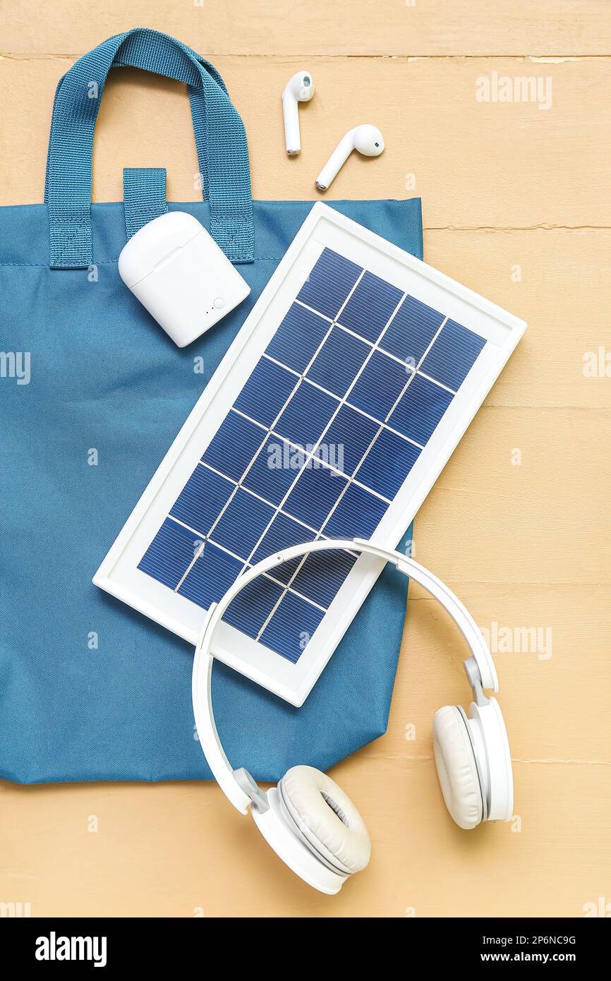 Composition with portable solar panel, wireless earphones and bag on ...