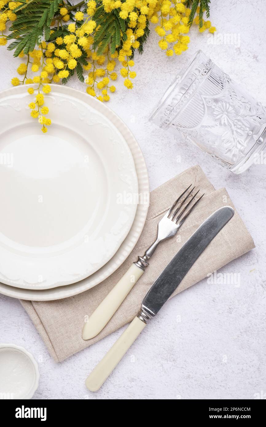 Table setting with beautiful mimosa flowers on grey grunge background ...