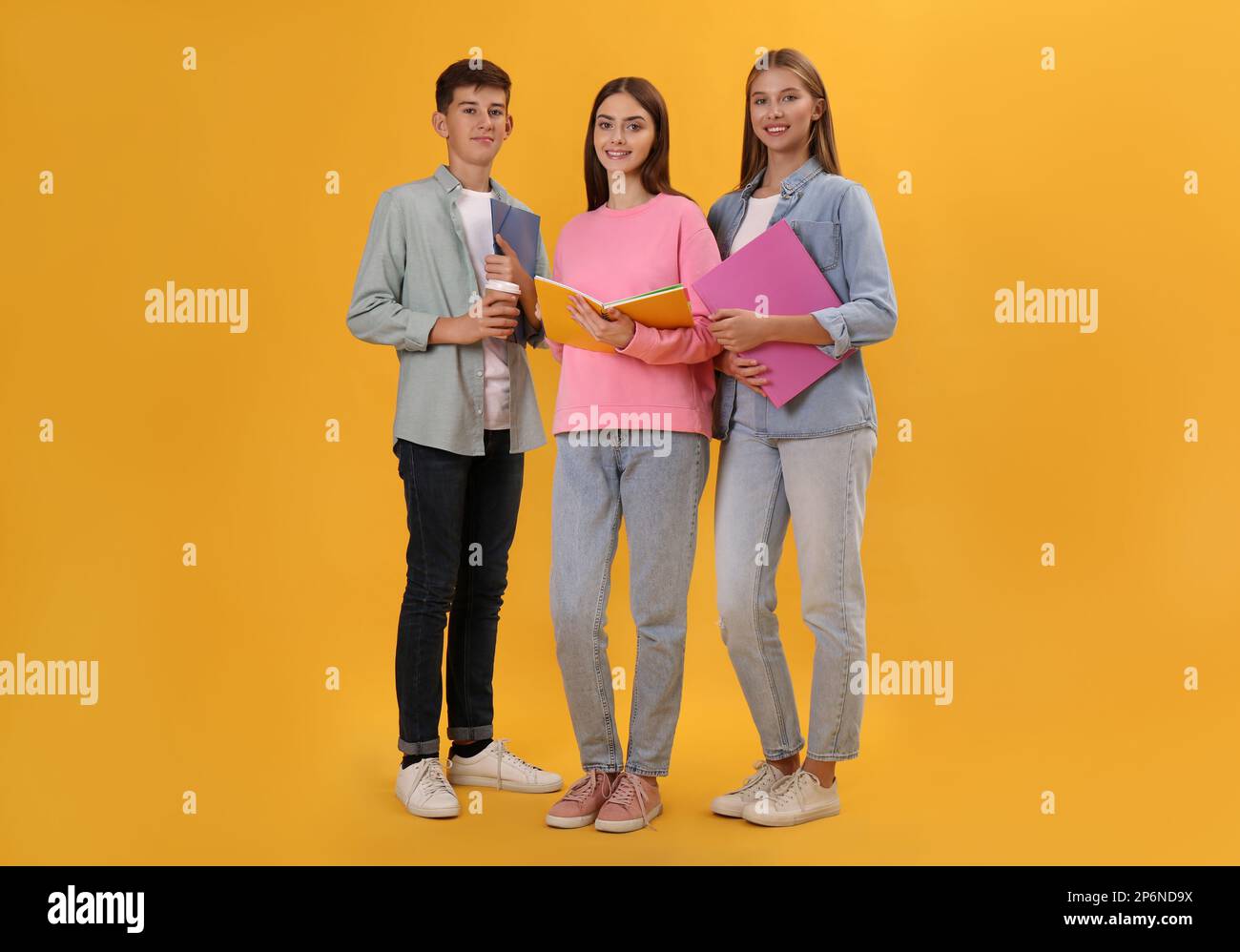 Group of teenage students with stationery on yellow background Stock ...