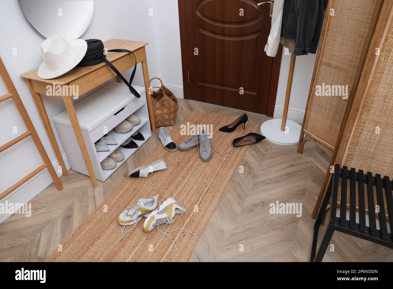 Shelving unit and scattered shoes on floor in hall Stock Photo - Alamy