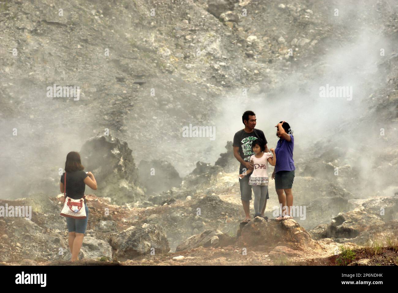 Visitors are having recreational time on fumarole field at Bukit Kasih ...