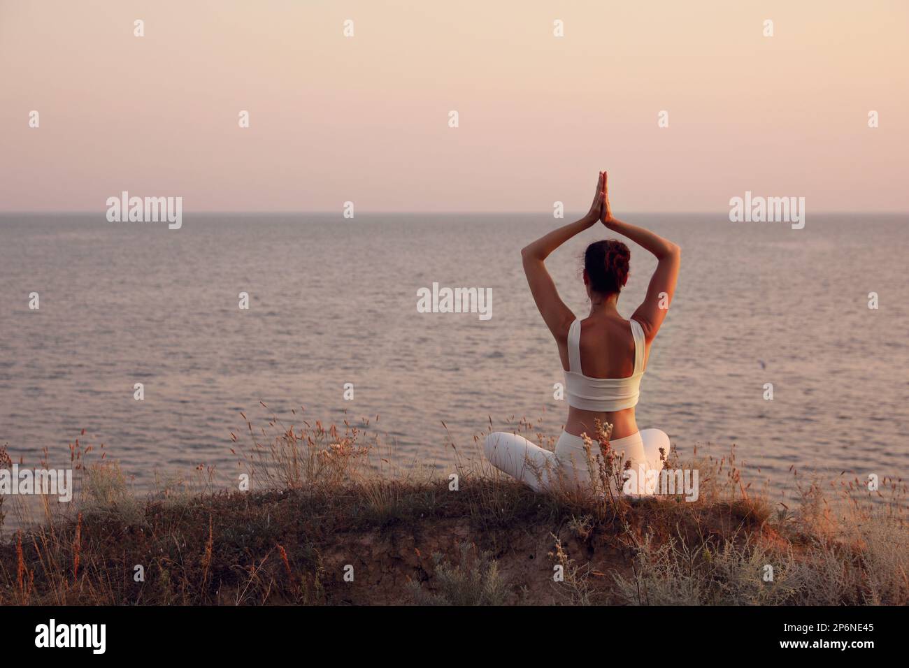 Woman meditating near sea, back view. Space for text Stock Photo - Alamy