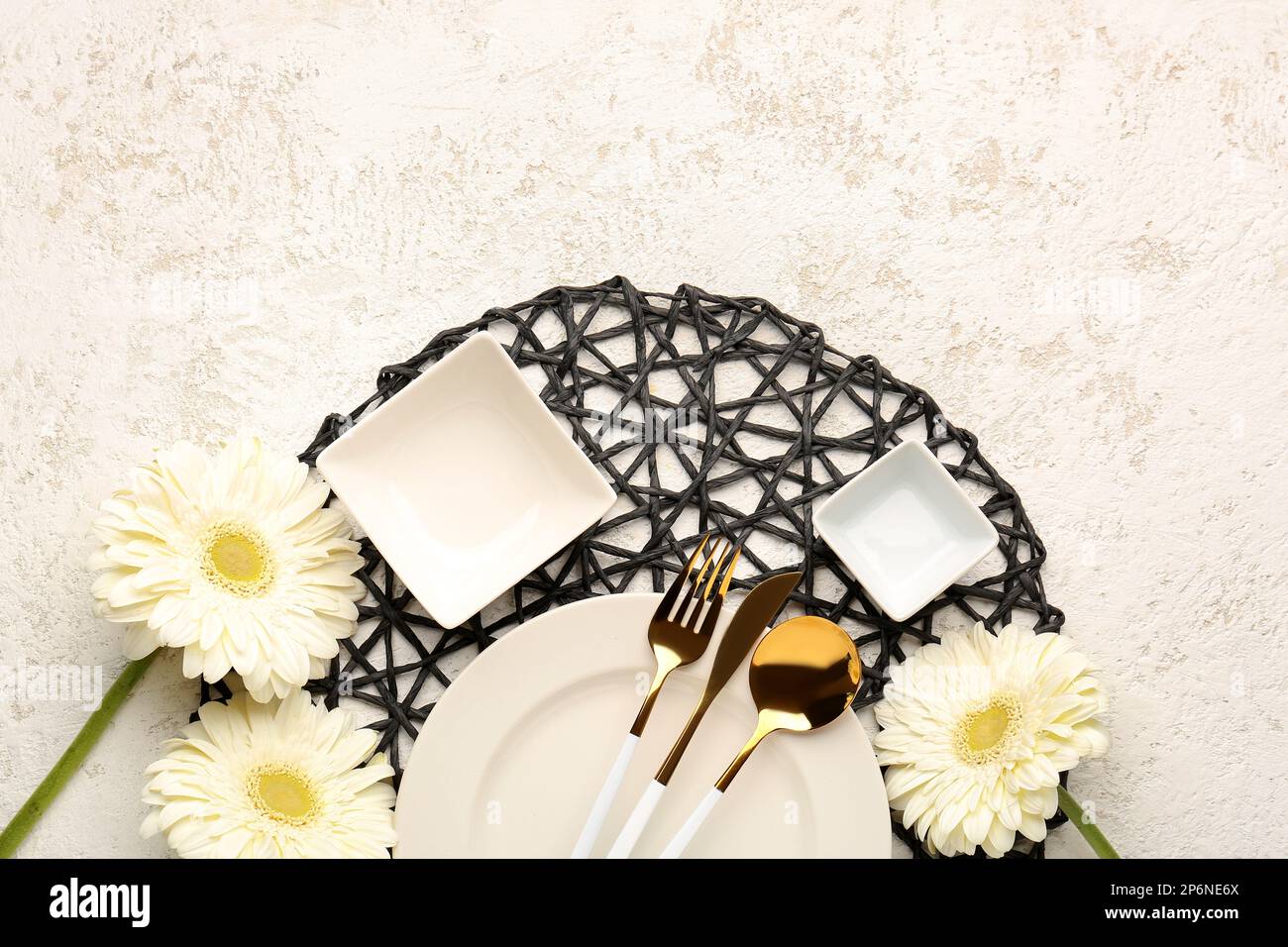 Table setting with beautiful gerbera flowers on beige grunge background ...