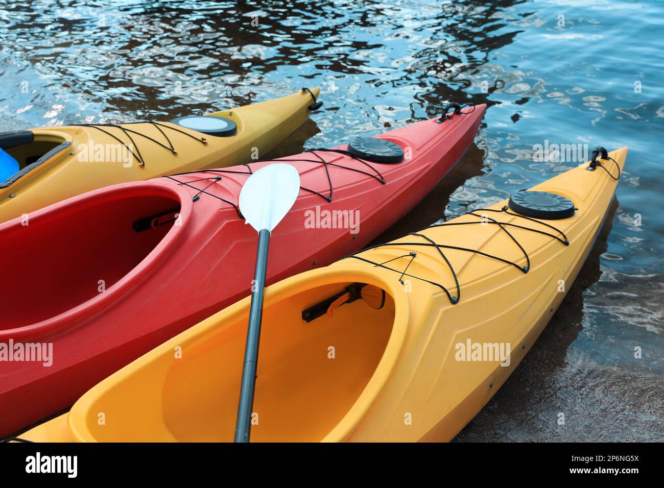 Modern kayaks with paddle on beach near river. Summer camp activity ...