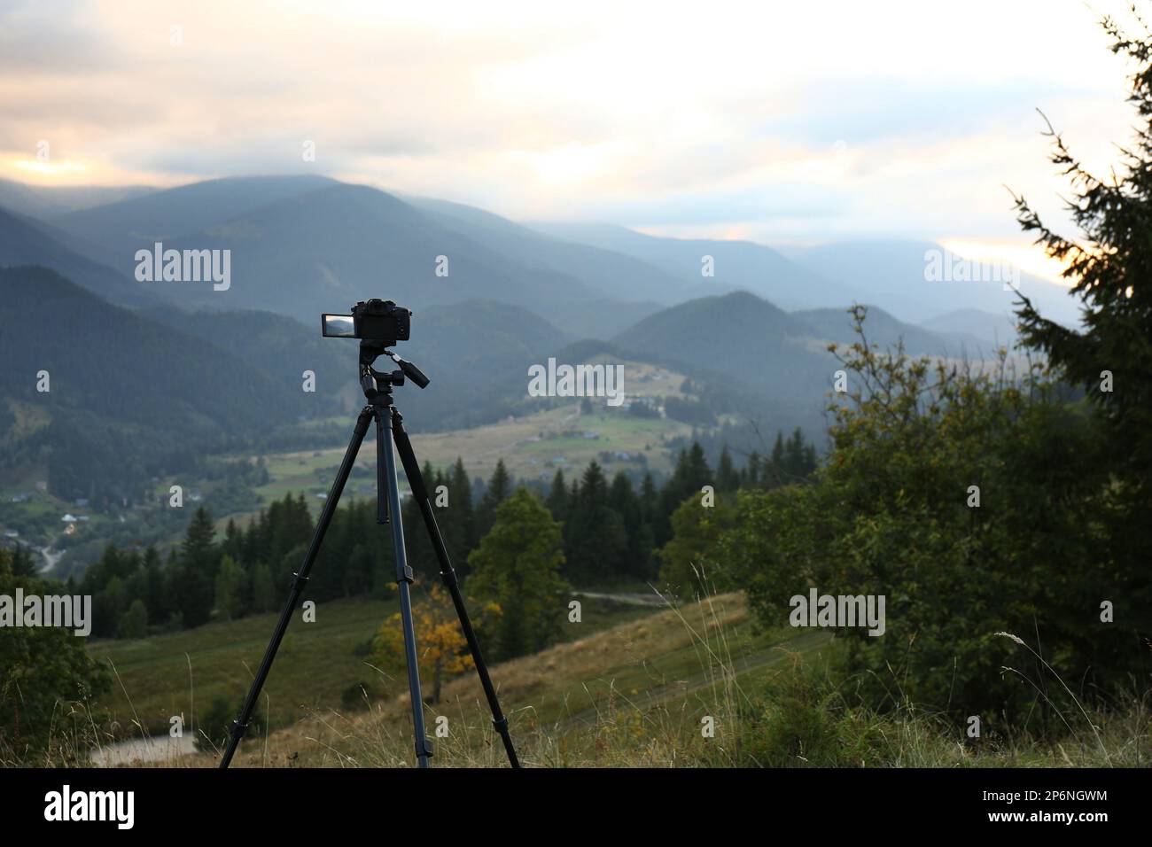 Taking video with modern camera on tripod in mountains Stock Photo - Alamy