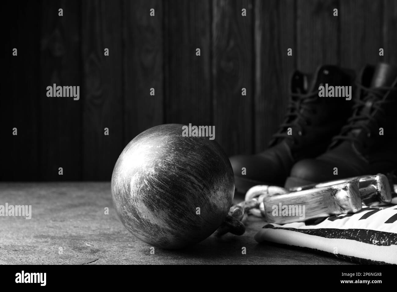 Prisoner ball with chain, jail clothes and boots on grey table Stock ...