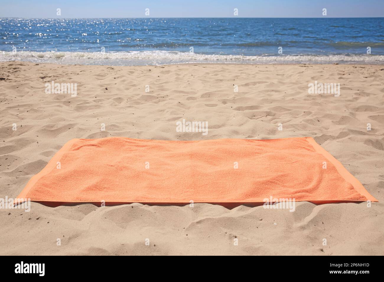 Soft orange beach towel on sandy seashore Stock Photo - Alamy