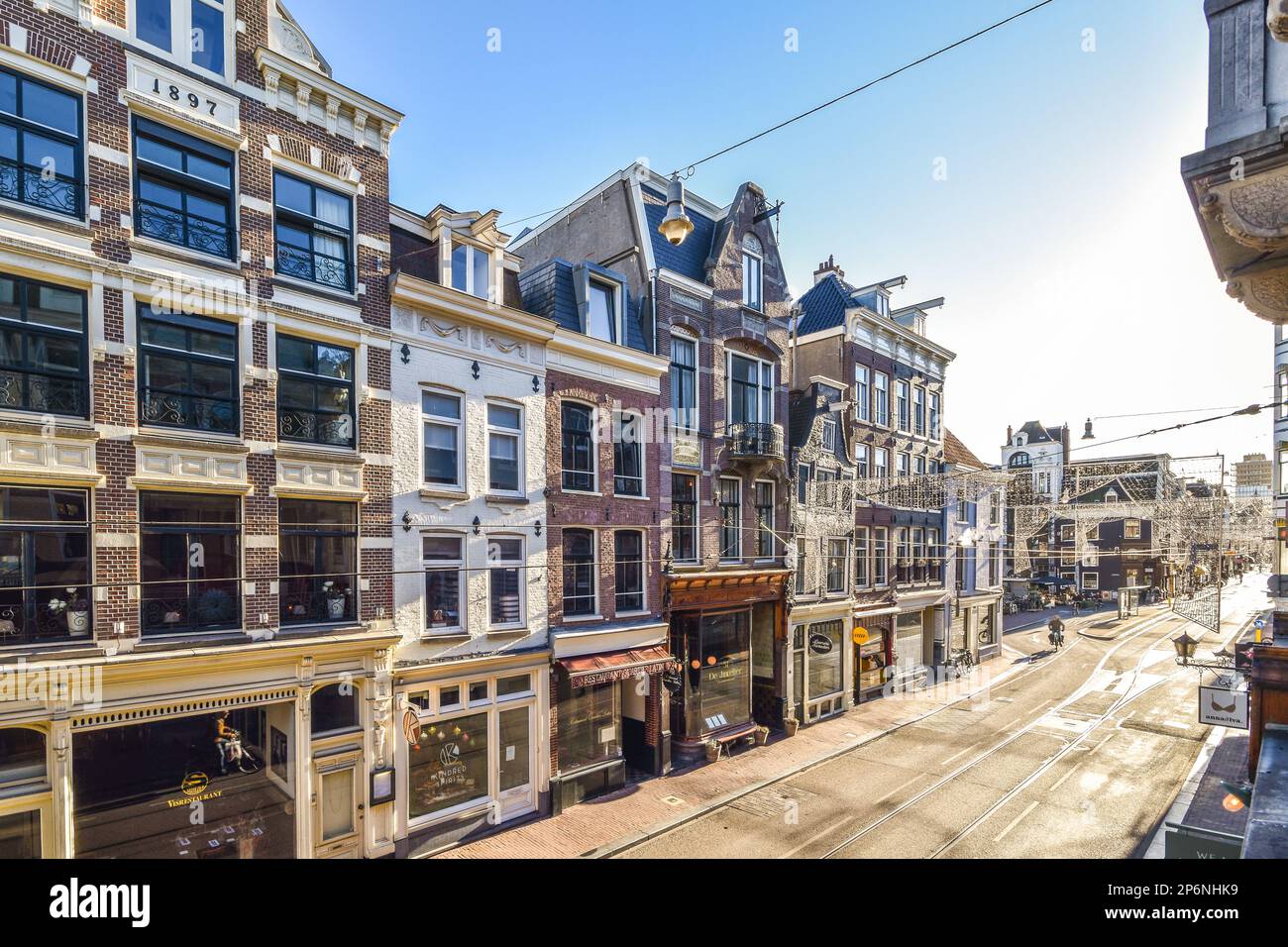 a city street with buildings on both sides and people walking down the ...