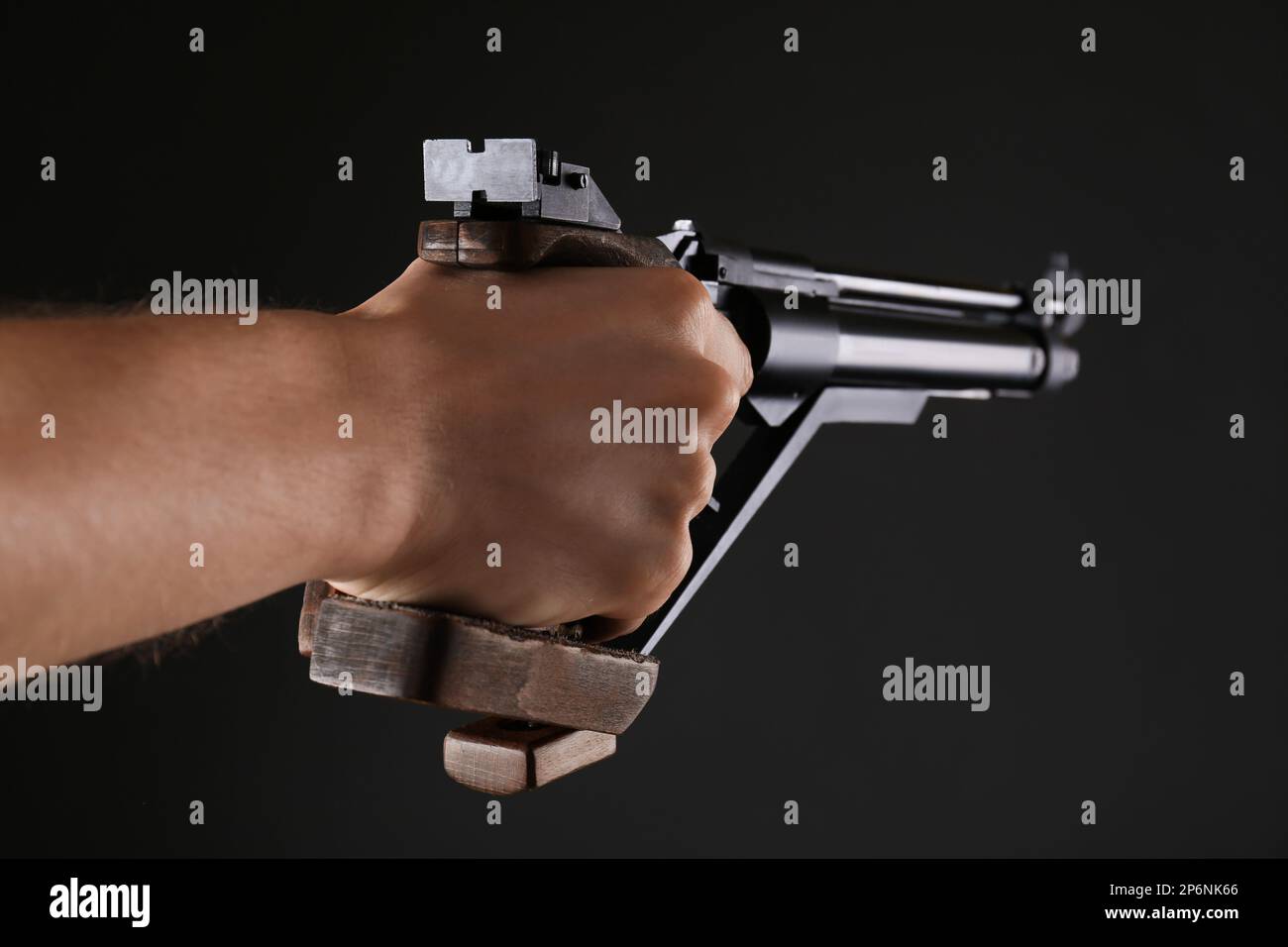 Gun shooting sport. Man aiming standard pistol on dark background ...