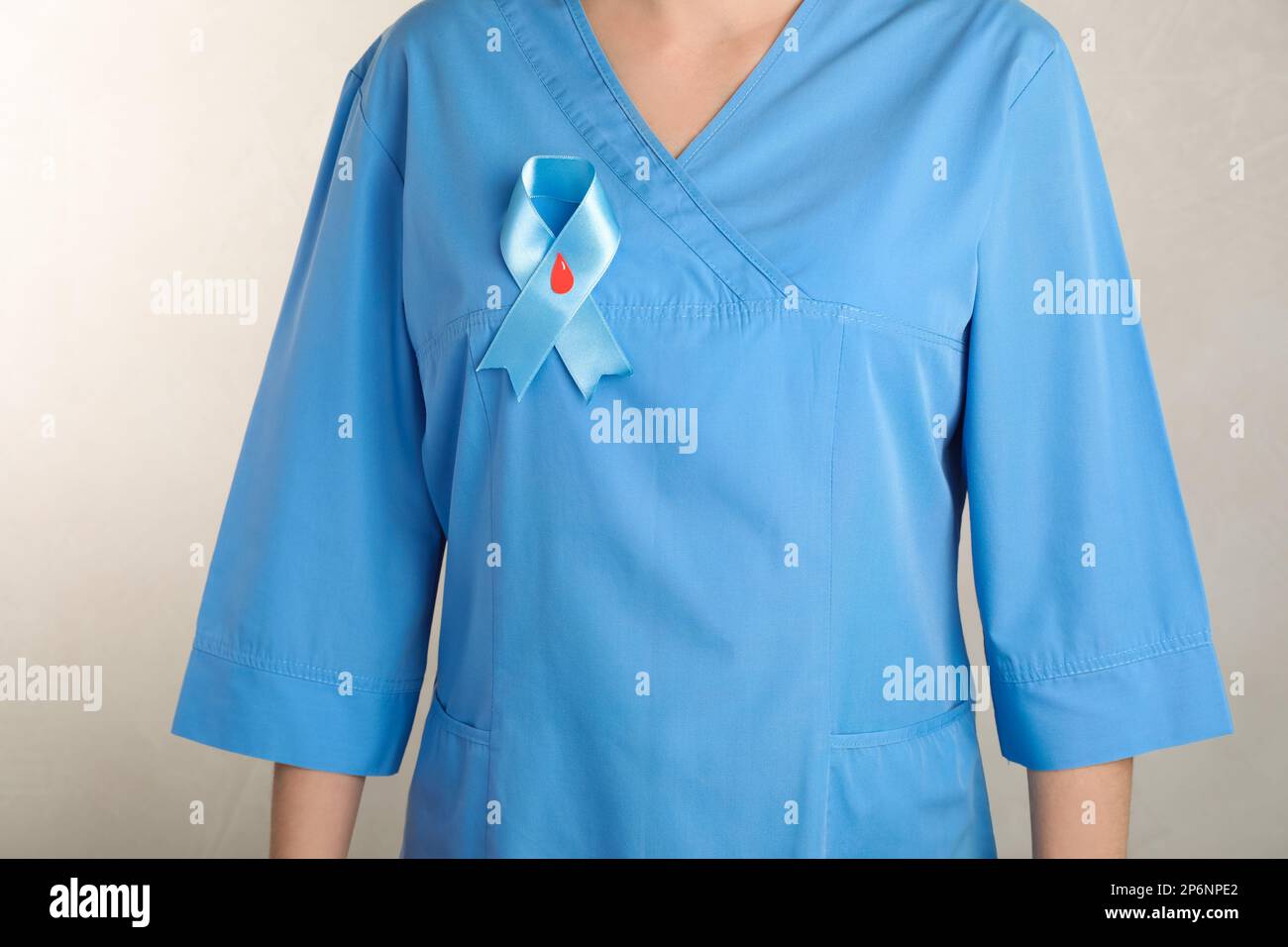 Doctor with light blue ribbon and paper blood drop, closeup. World ...