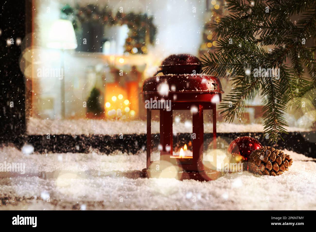 Snow falling onto window sill with Christmas lantern outdoors Stock ...