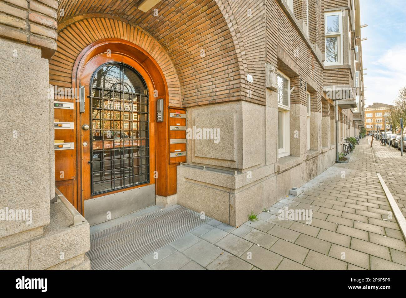 a brick building with an arched window on the front door and sidewalk ...