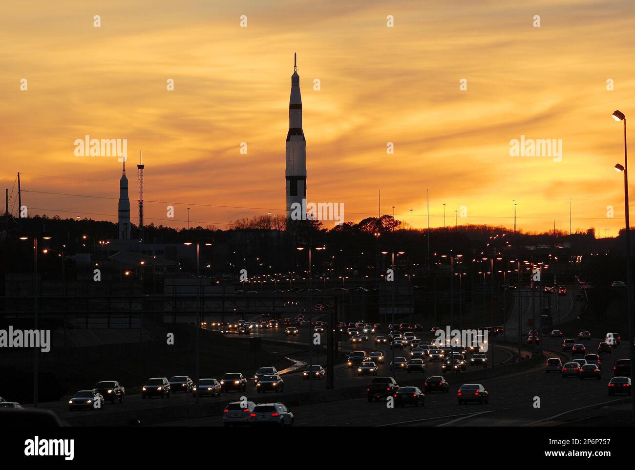 Traffic fills I-565 as the sun set behind the Saturn 1B, left and ...