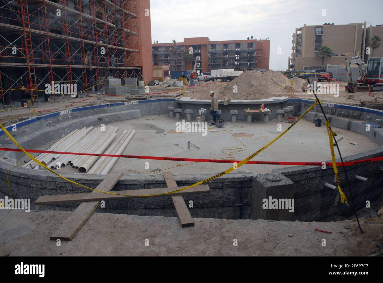 A workman walks inside a swimming pool that will feature a swim up bar ...