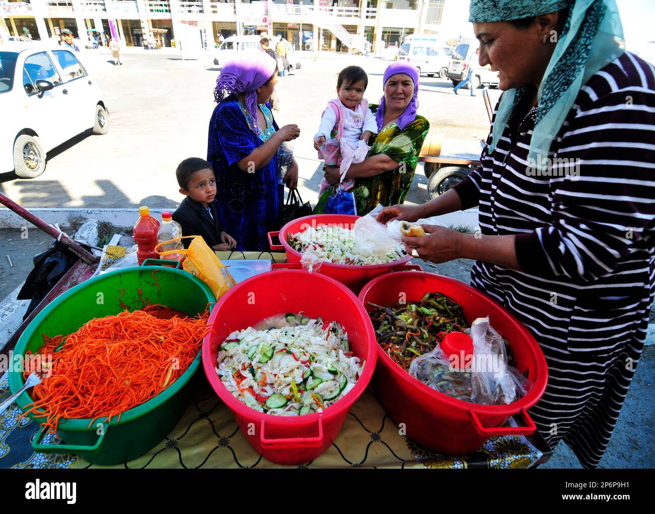 Uzbek women selling chopped carrot and cabbage at the colorful market ...