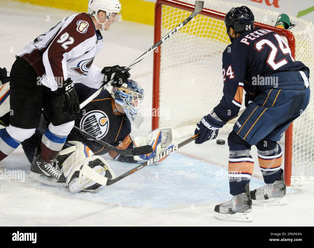 Edmonton Oilers goalie Devan Dubnyk, center, and teammate Theo Peckham ...