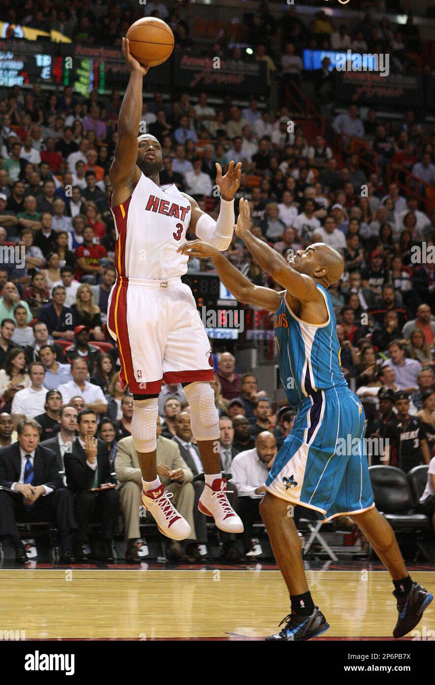 The Miami Heats' Dwyane Wade shots over New Orleans Hornet Jarrett Jack ...