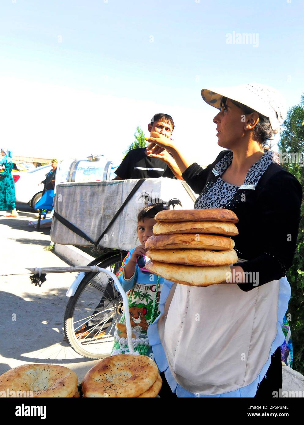 An Uzbek woman selling Obi Non- a traditional Uzbek / Tajik bread sold ...