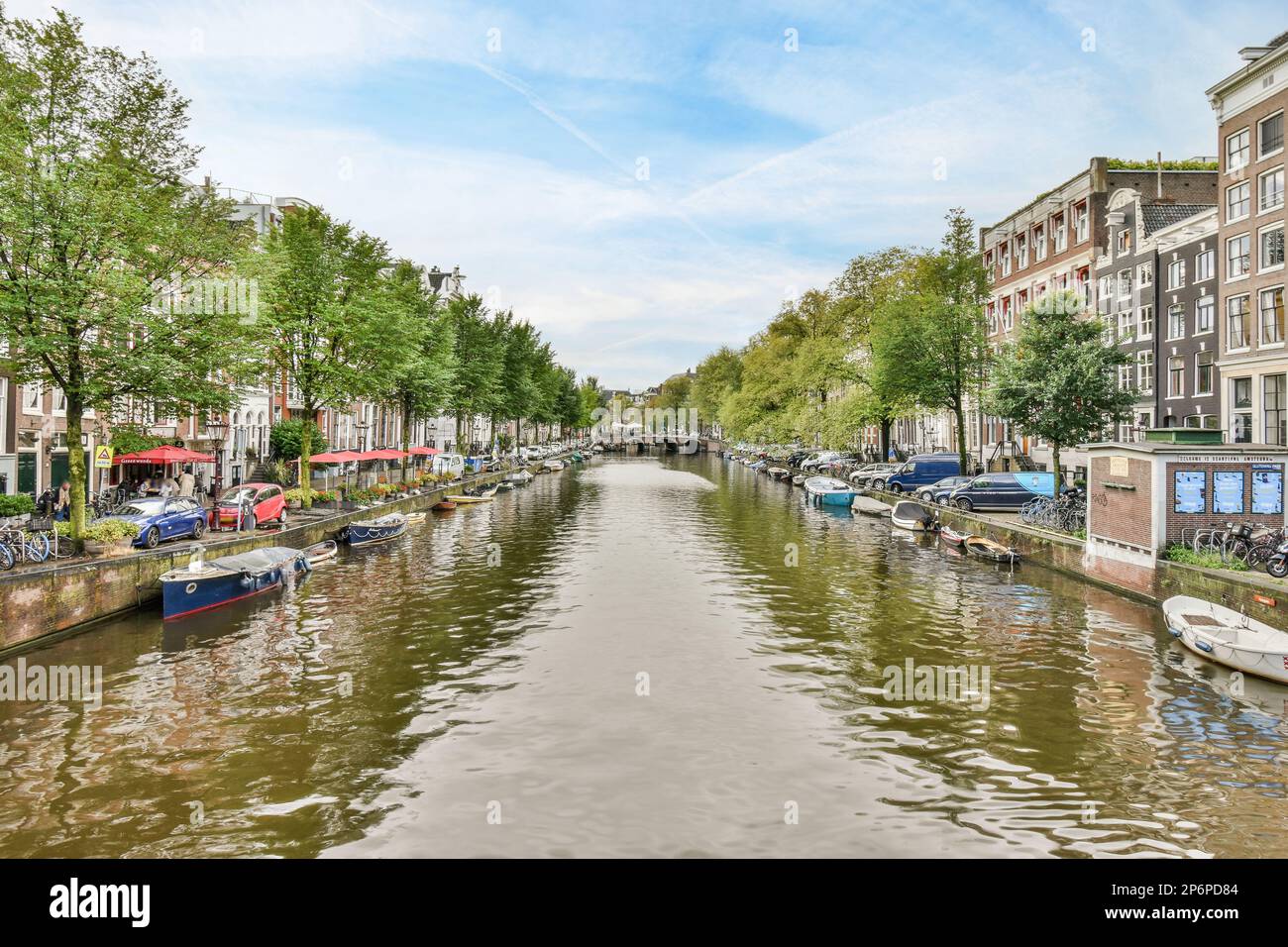 a canal with boats and buildings on both sides, in the background is a ...