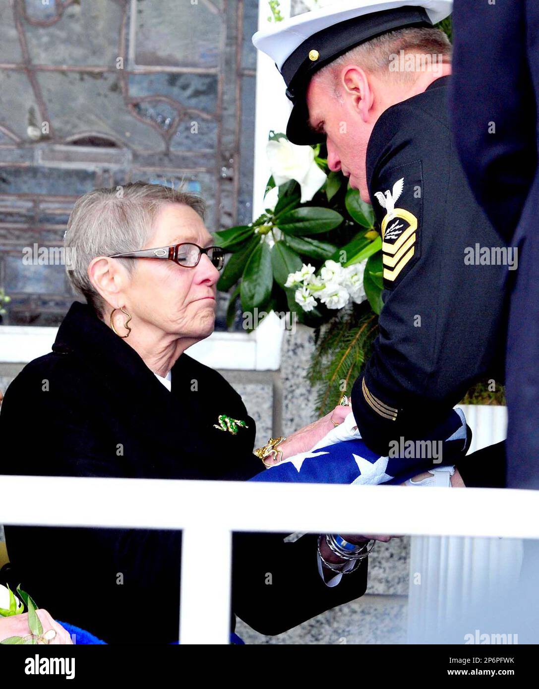 U.S. Navy Chief Petty Officer Dale Maxwell presents the American Flag ...