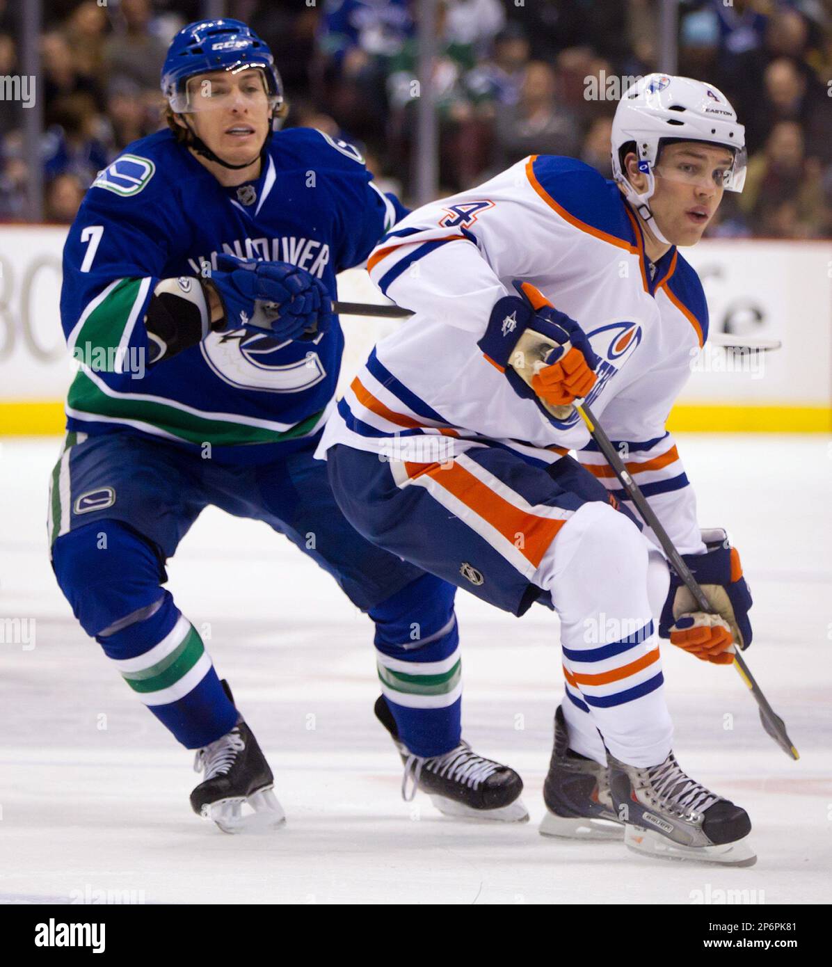 Edmonton Oilers' Taylor Hall, right, is checked by Vancouver Canucks ...