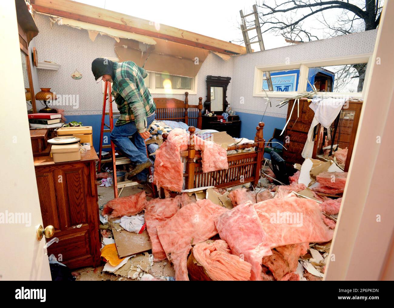Jeff Everett climbs down from a ladder Monday in Kim and Susan Carders ...