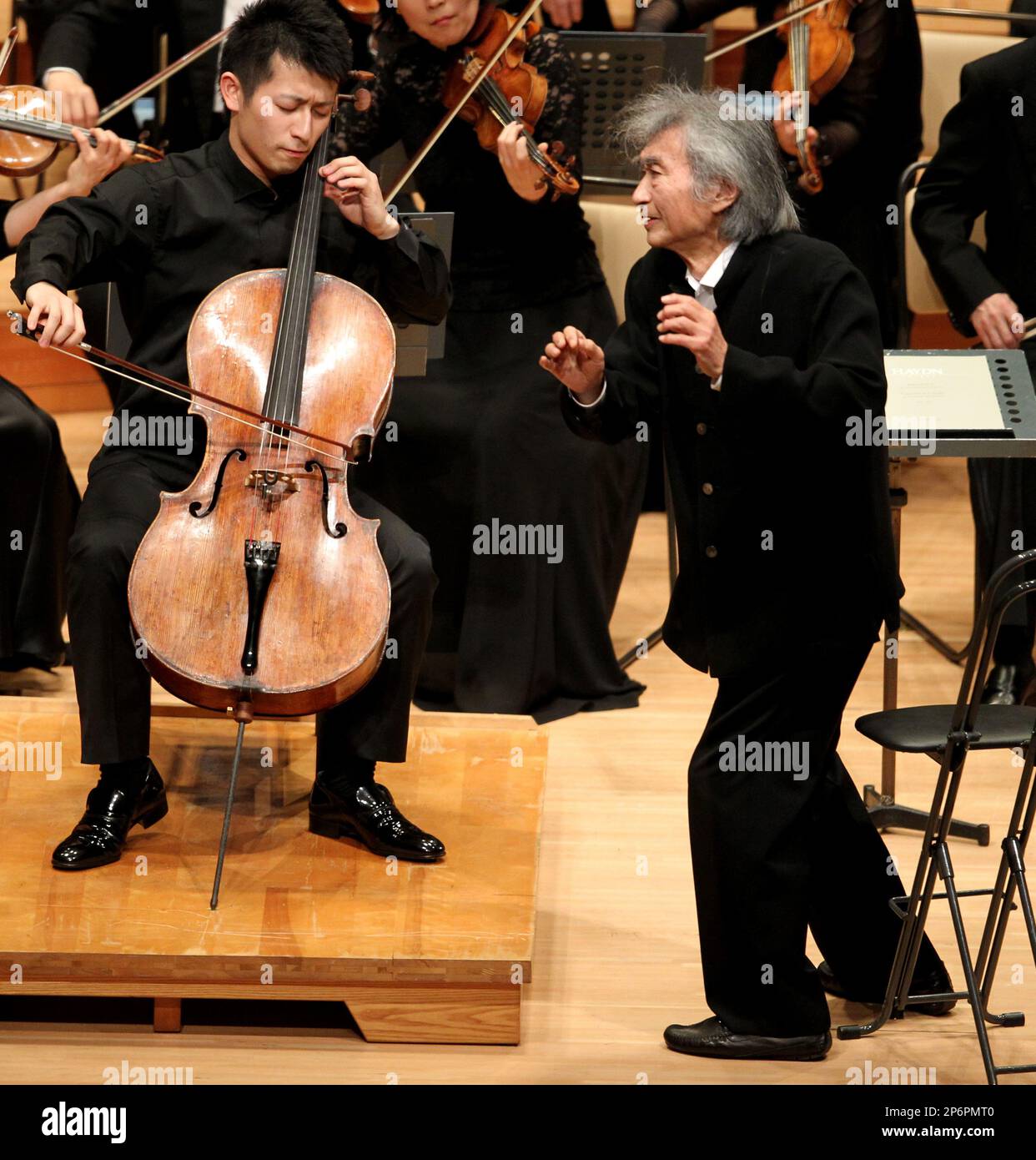 Japanese conductor Seiji Ozawa, 76, (R) directs a baton with ...