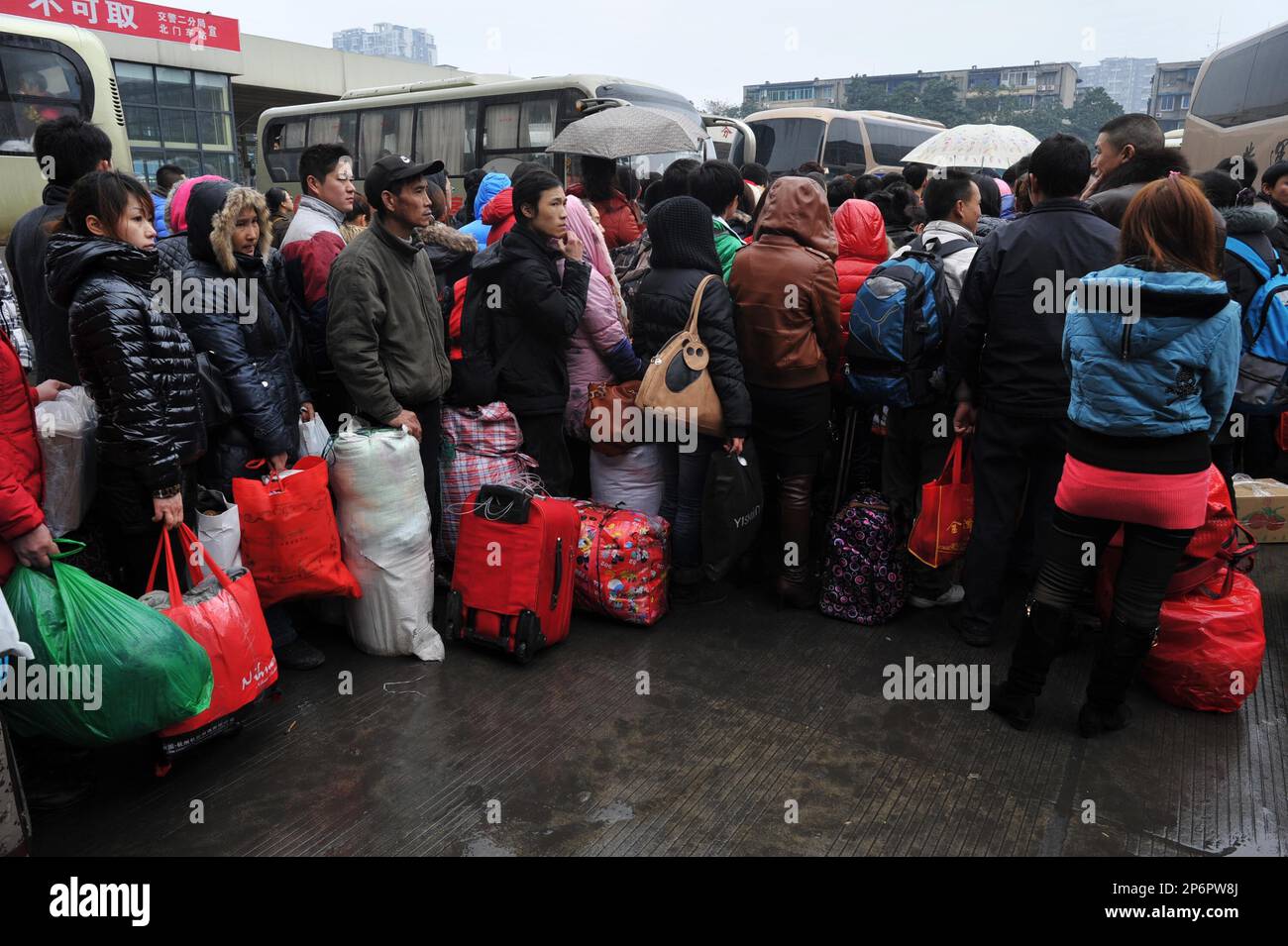 People queue up for their buses at a long distance bus station in ...