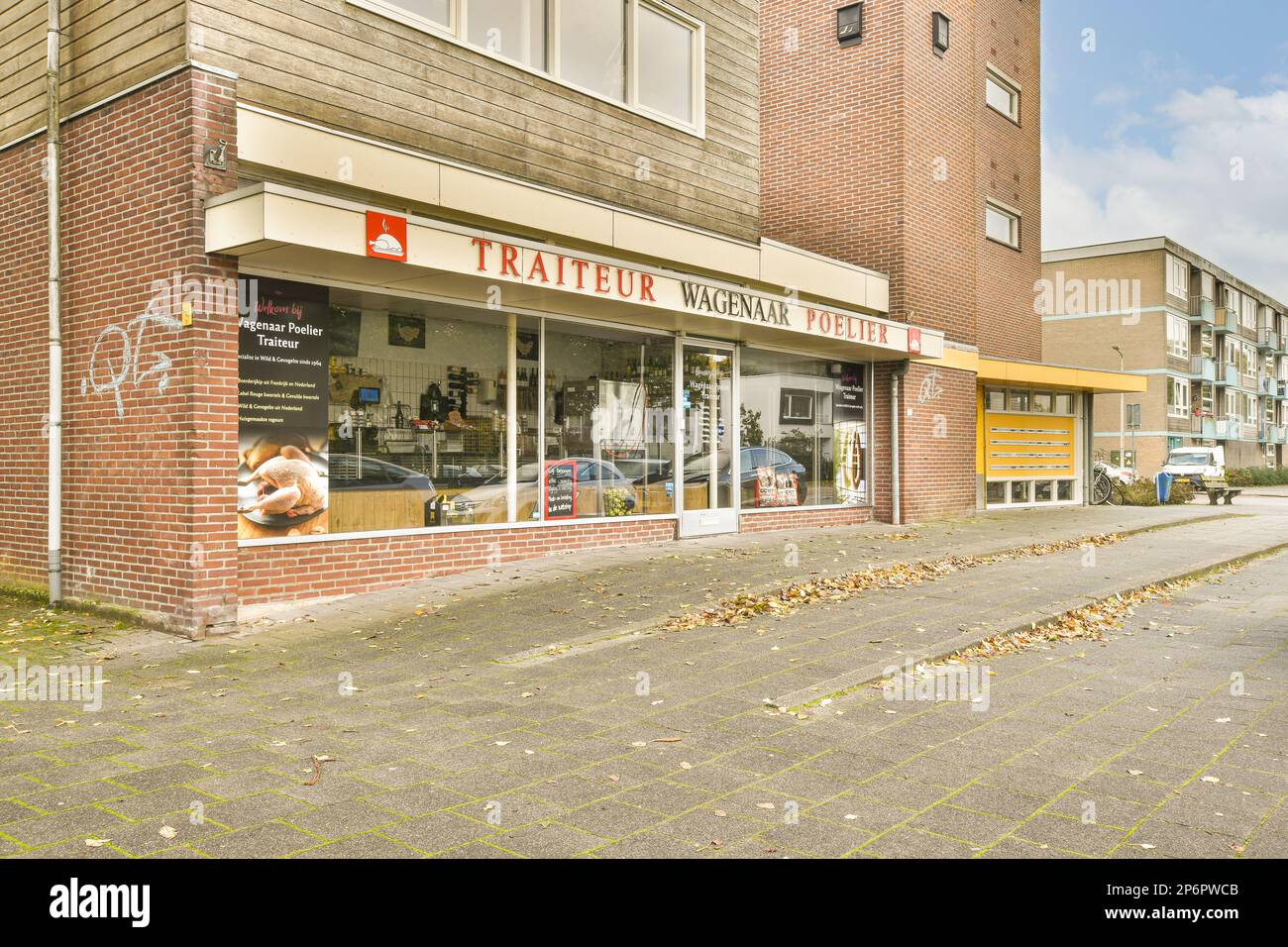 an empty street in front of a brick building that has been vandaled for ...