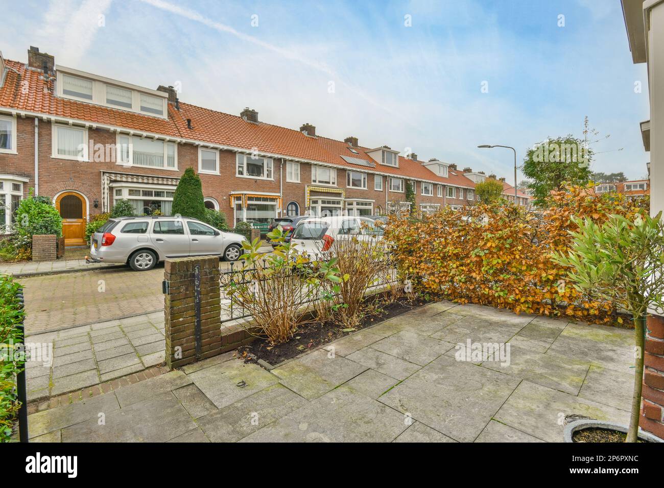 an outside area with cars parked on the street and houses in the ...