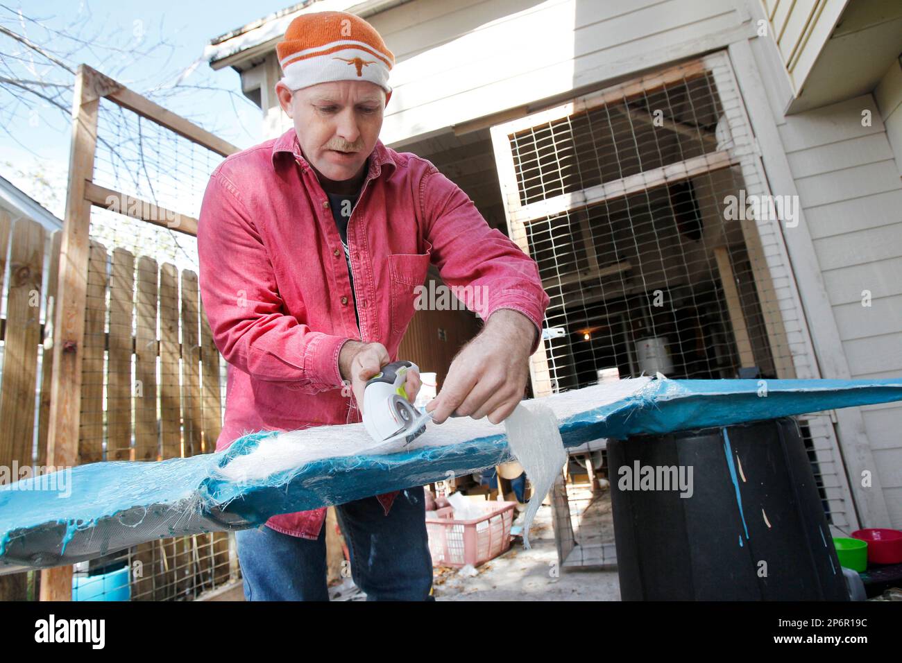 Artist David Allgood trims and layers pieces of fiber glass on what ...