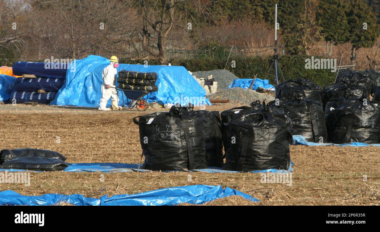 Workers bring soil contamination with radioactive substances into a ...
