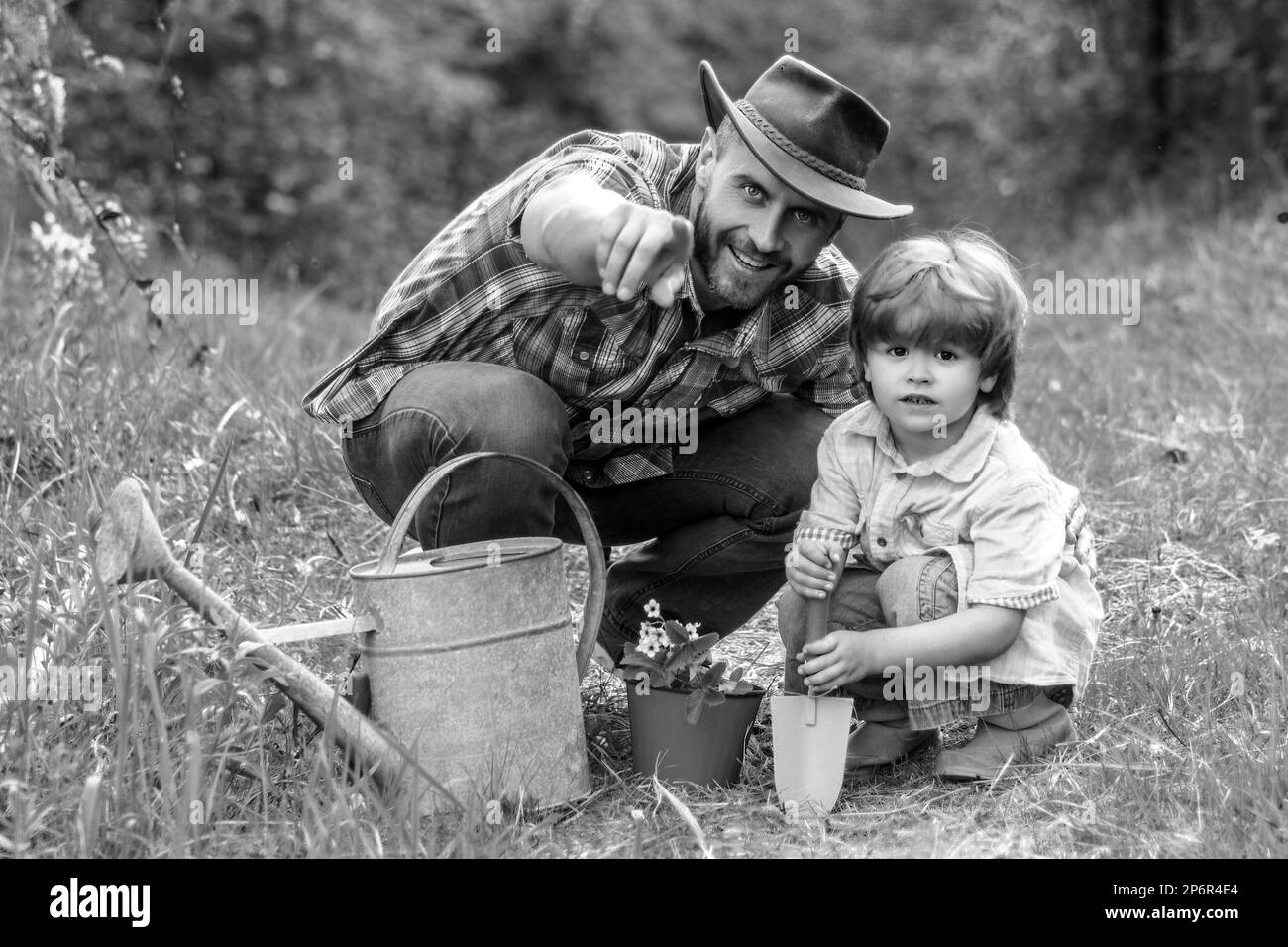 Father and son gardening. Little son helping his father to plant the ...