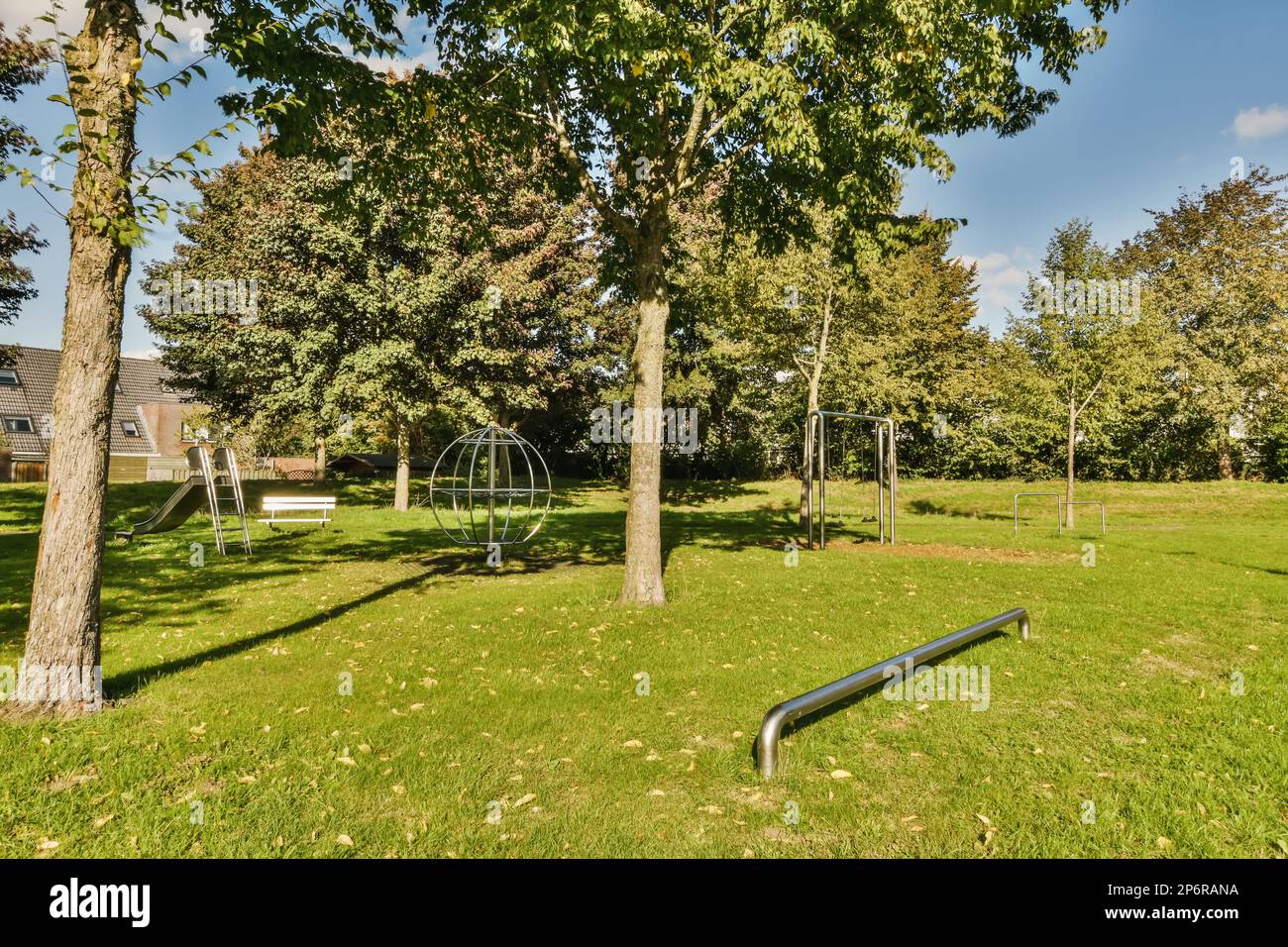an empty park with swings, benches and trees in the fore - image was ...