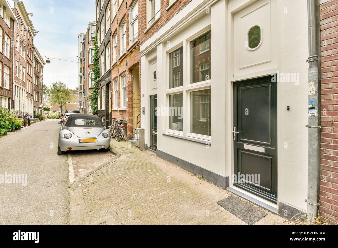 a car parked on the side of a street in front of a brick building with ...