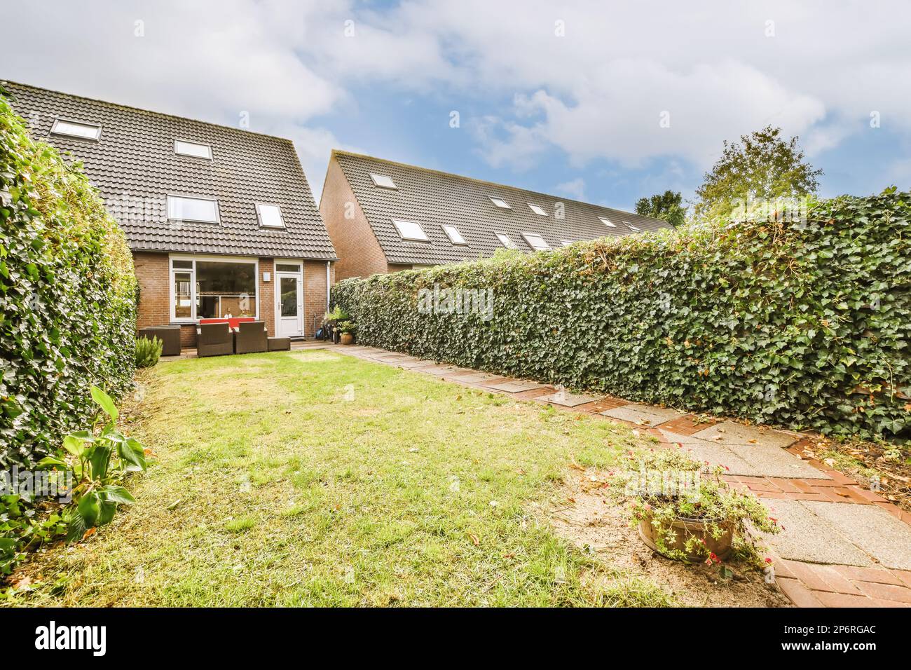 a house in the netherlands with hedges and bushes surrounding it is one ...