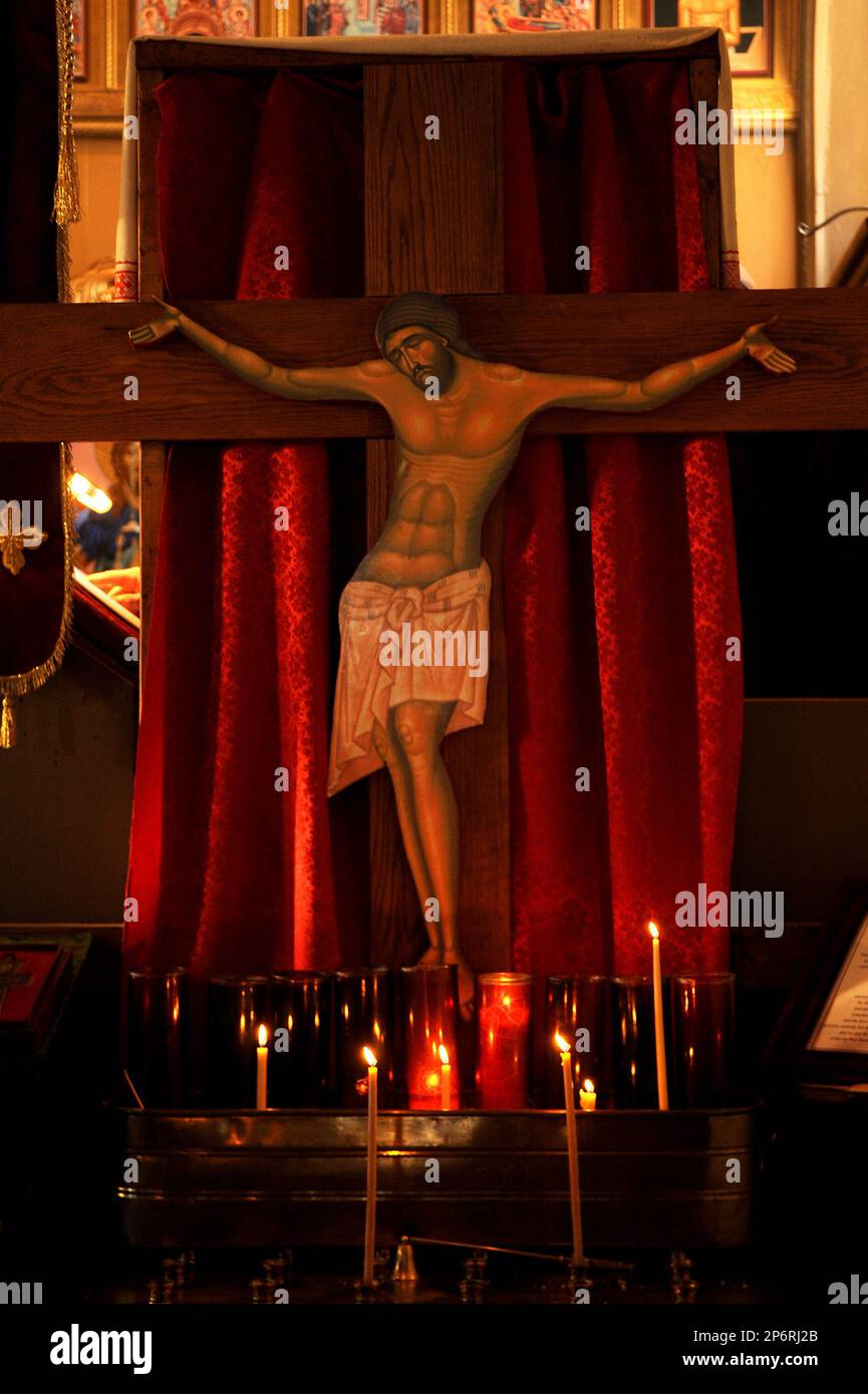 Candles burn under an image of Jesus Christ on Friday. Parishioners ...